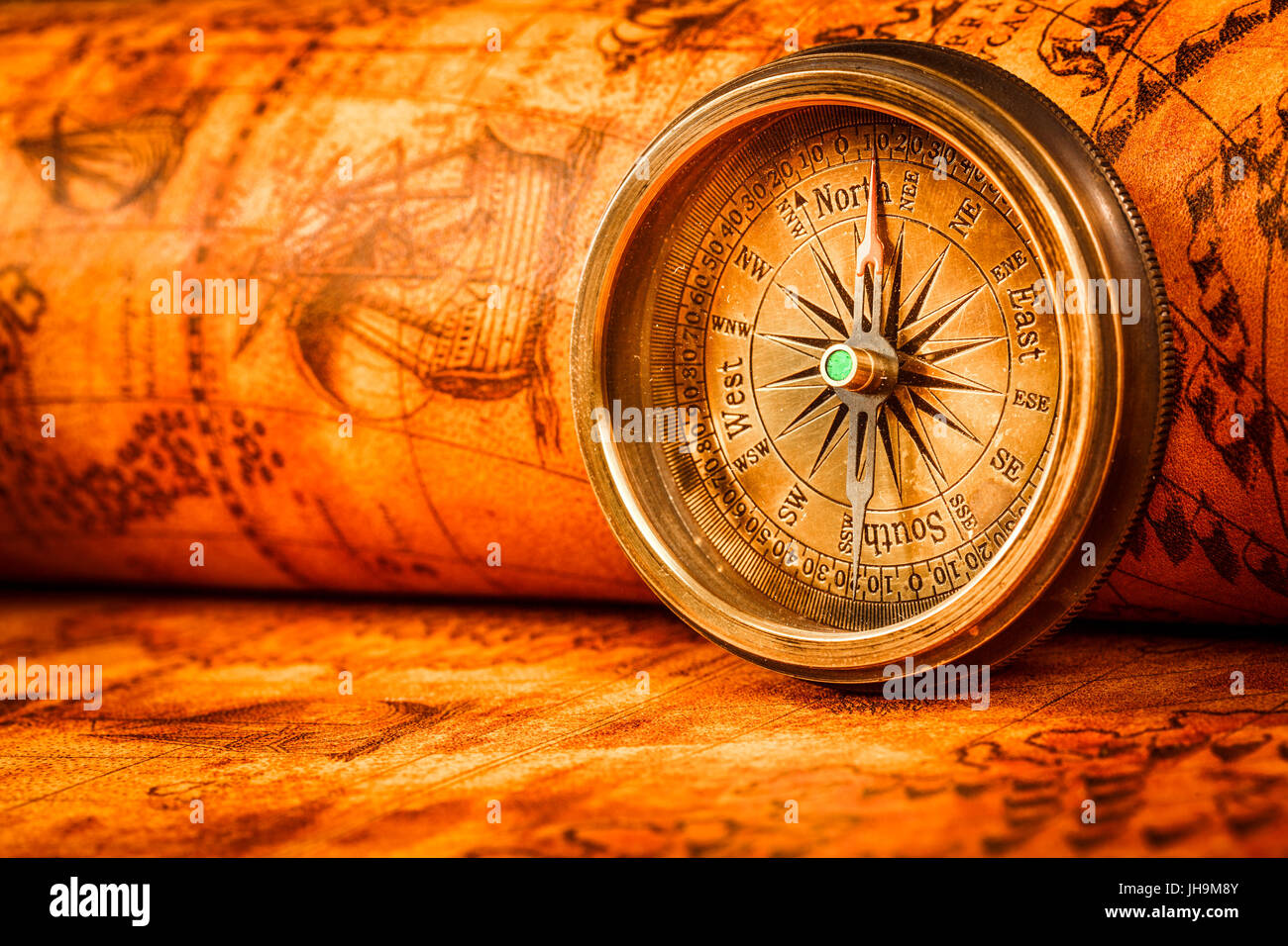 Vintage still life. Vintage compass lies on an ancient world map in ...