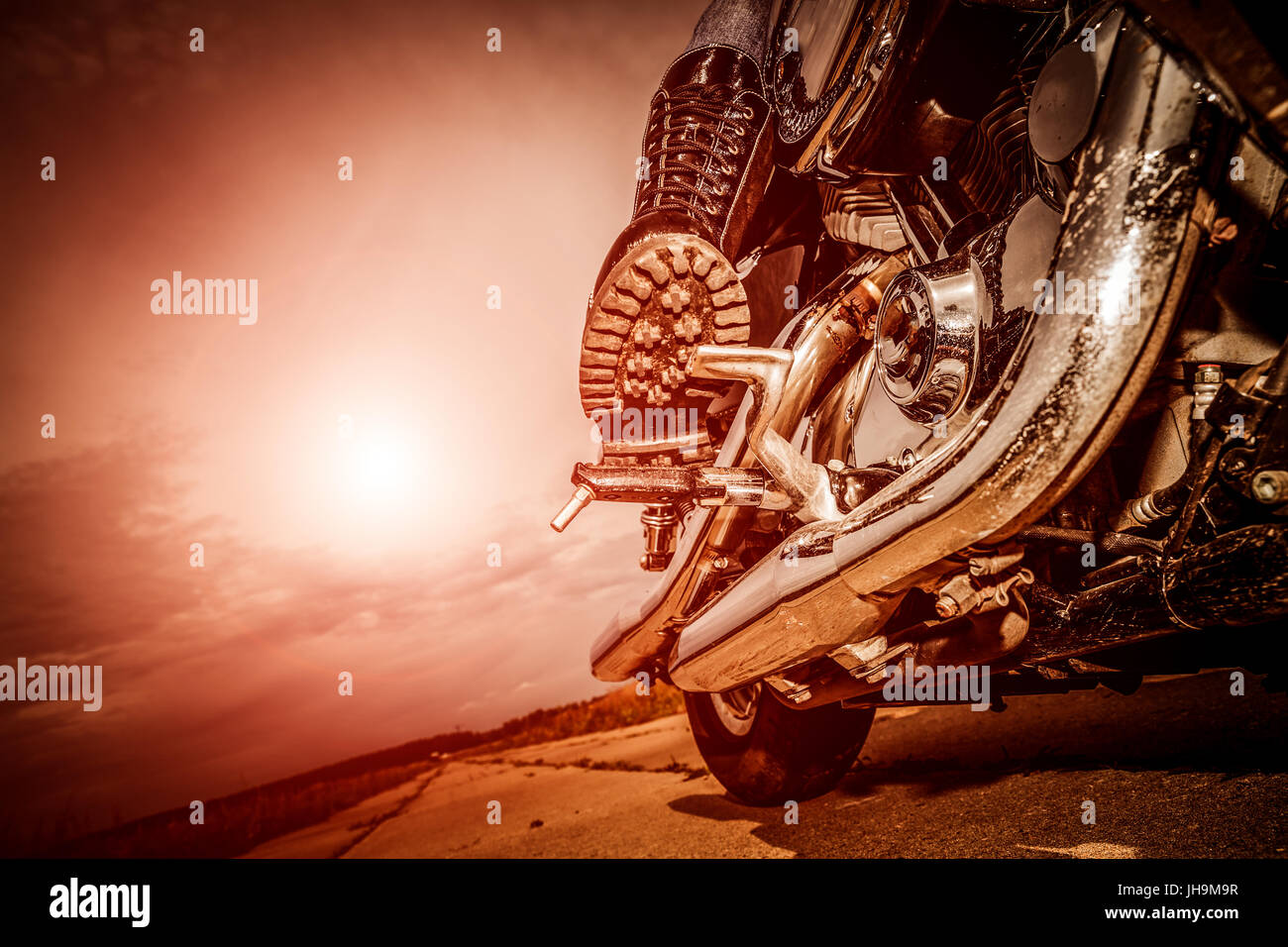Biker girl riding on a motorcycle. Bottom view of the legs in leather ...