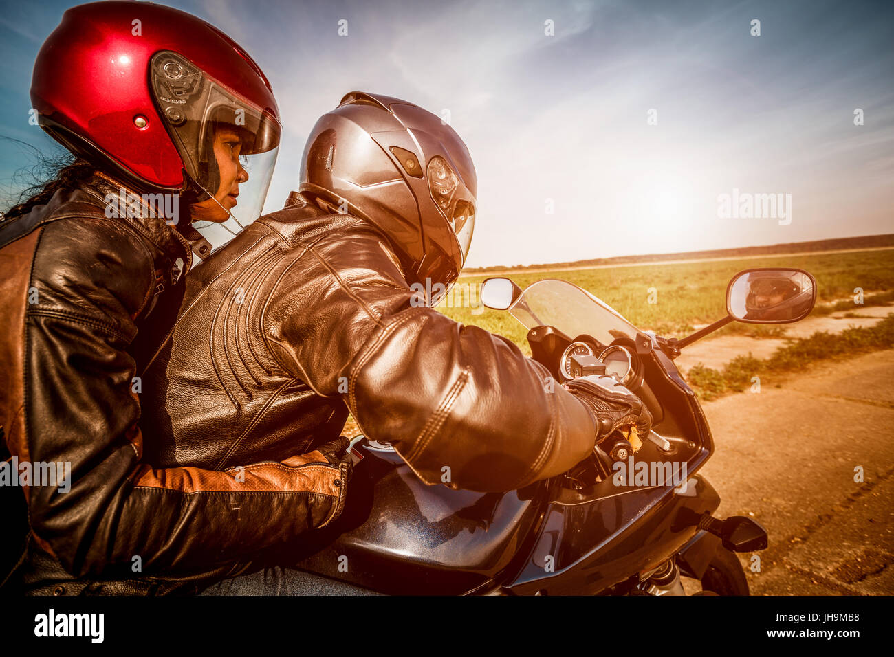 Couple Bikers in a leather jacket riding a motorcycle on the road Stock ...