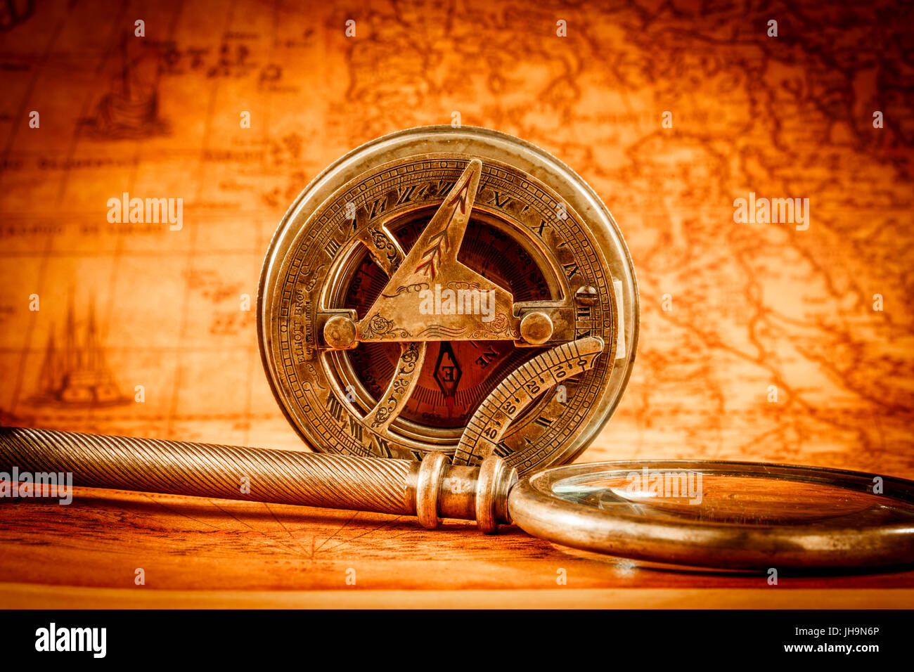 Vintage still life. Vintage magnifying glass lies on an ancient world ...