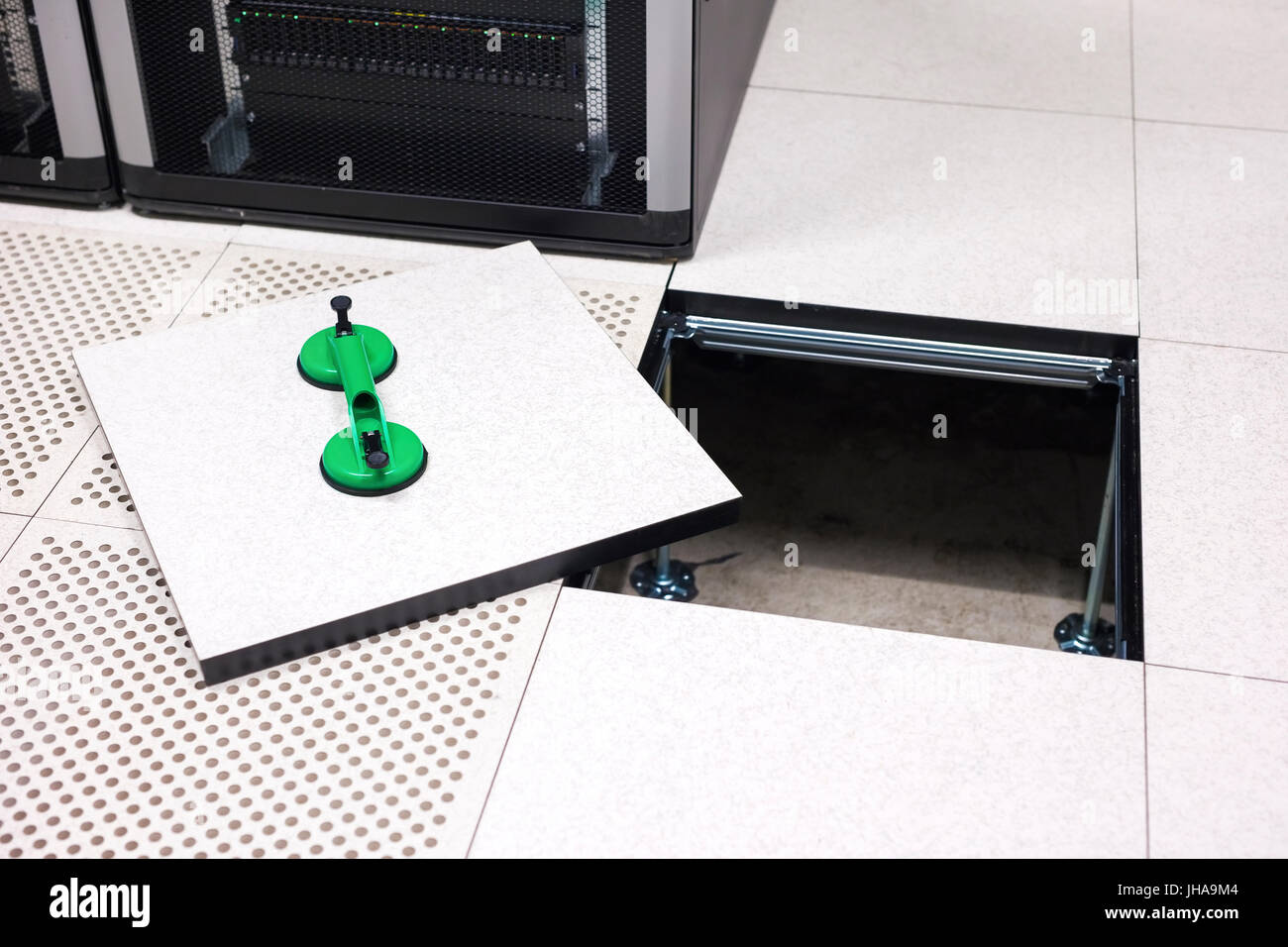 High angle view of lifted floor tile with vacuum suction cups in ...