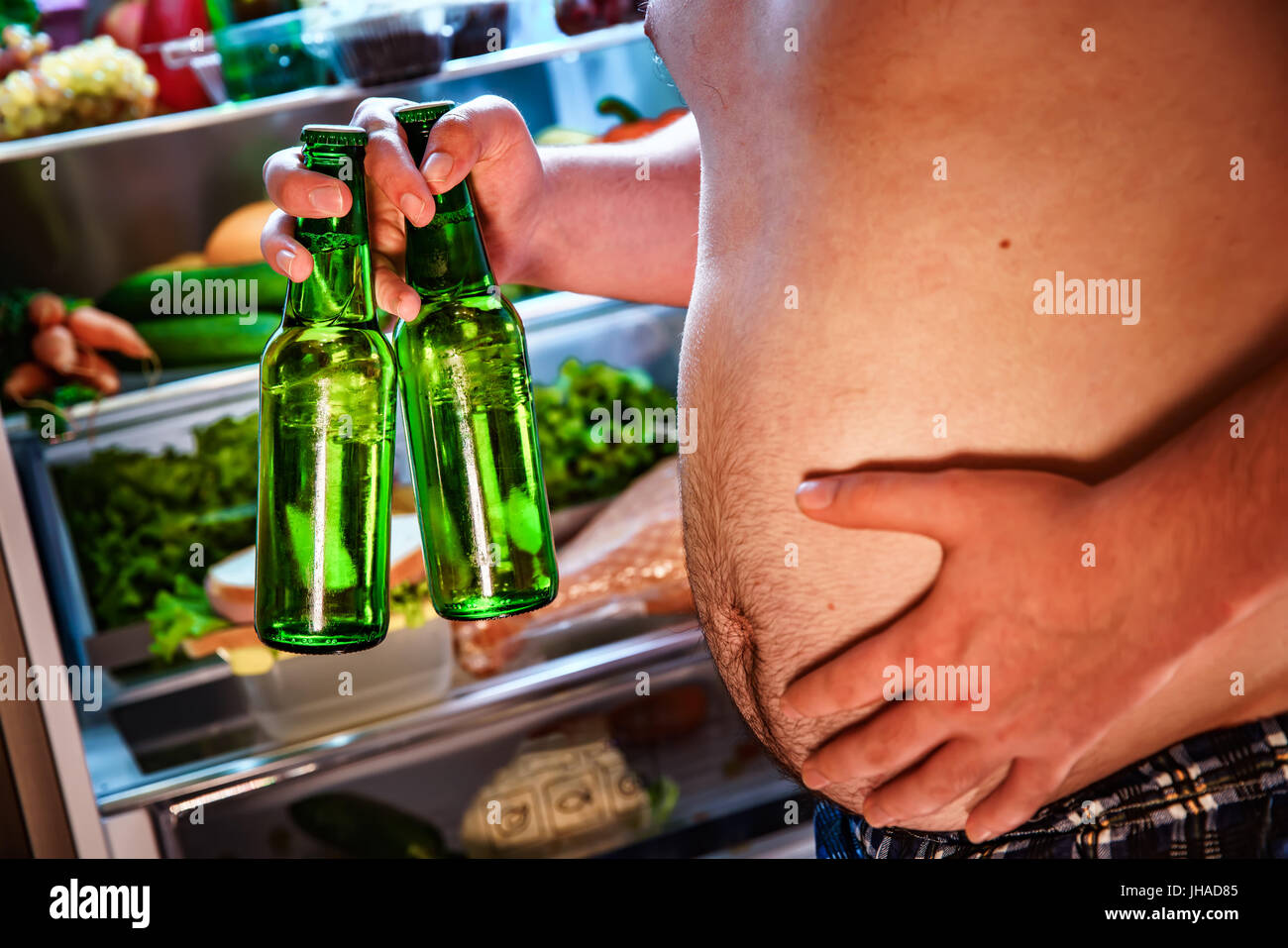 Fat man with a beer in his hand next to fridge Stock Photo - Alamy