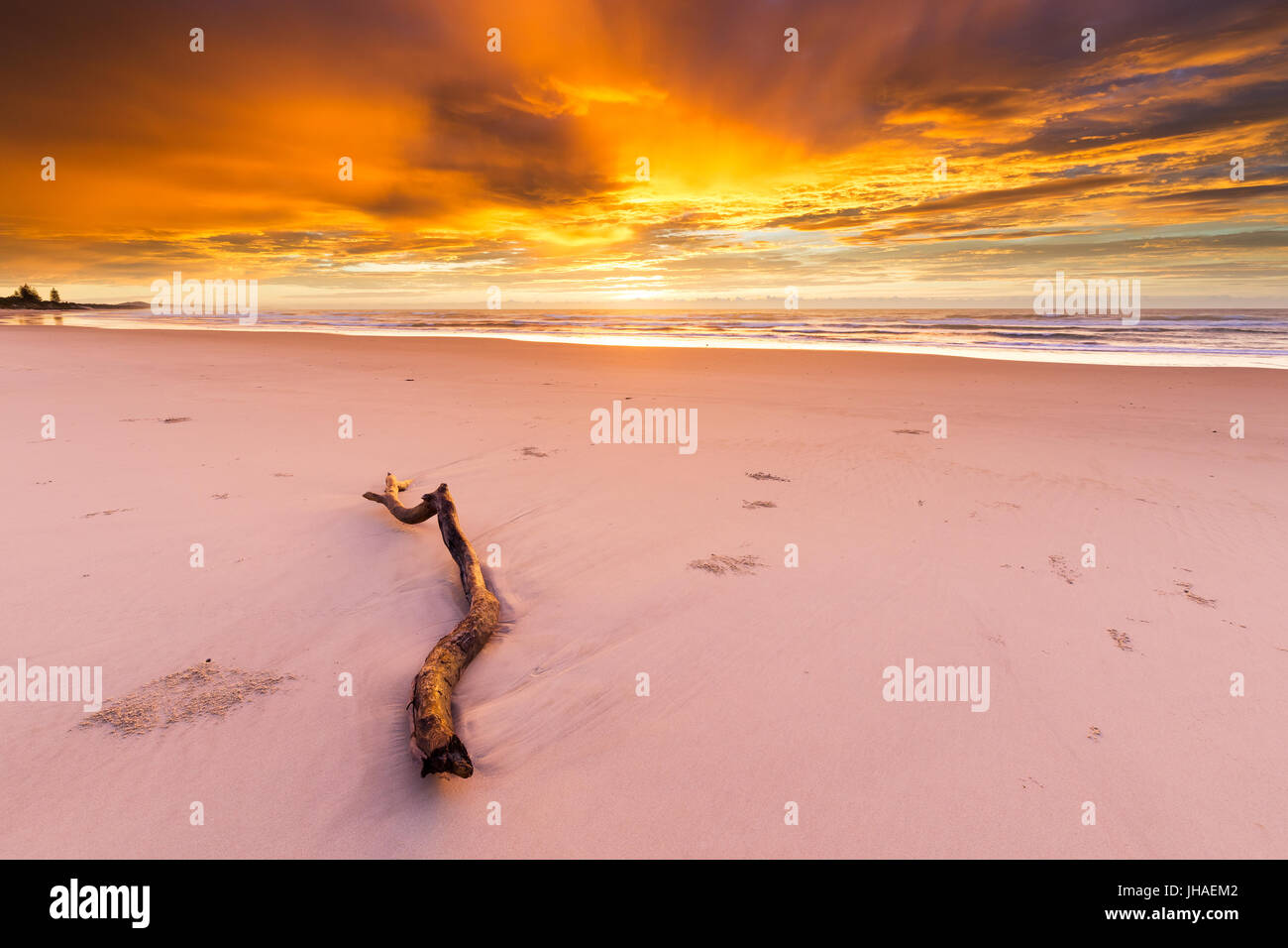 A driftwood log lies on the beach under an amazingly beautiful and ...