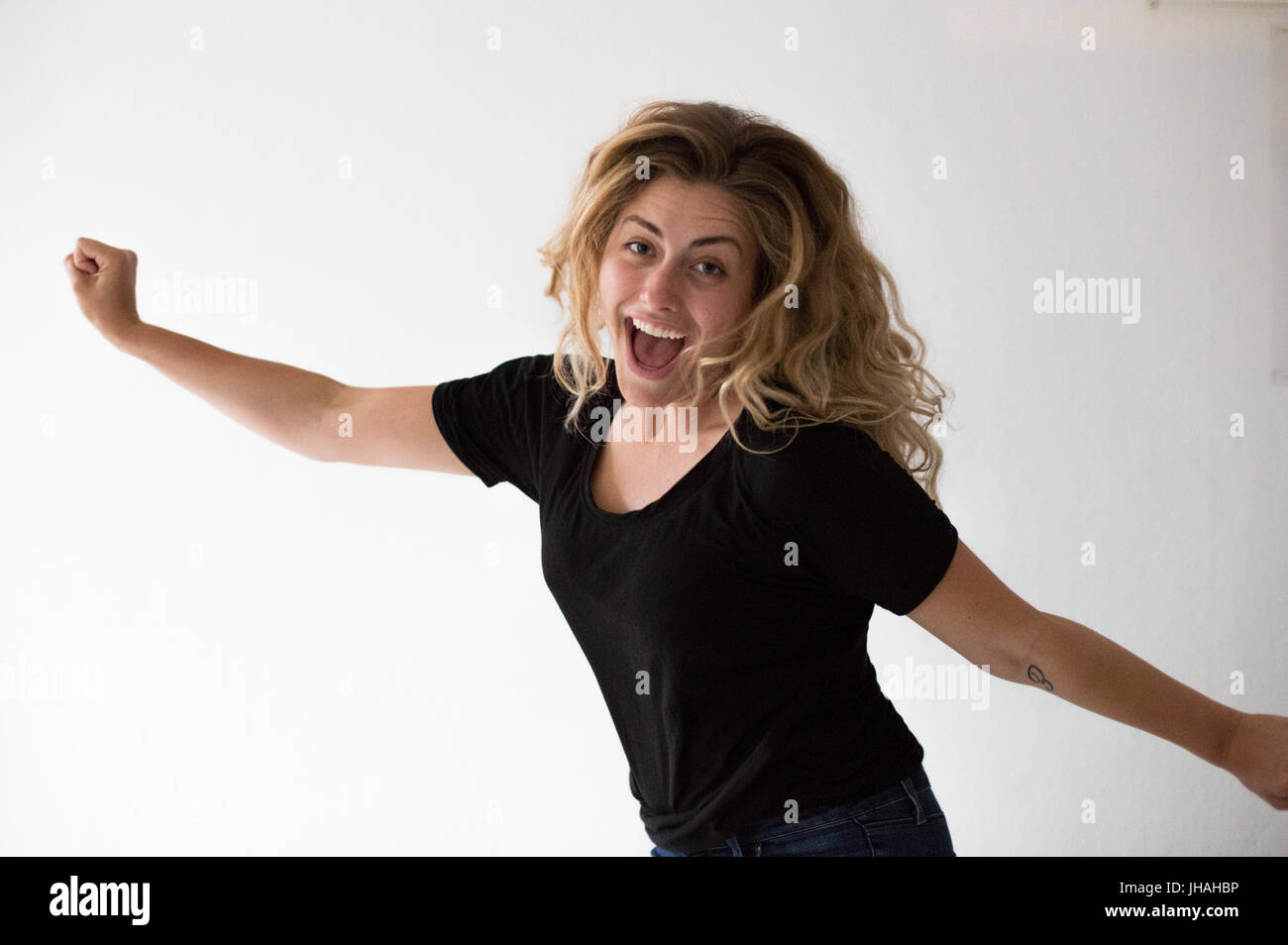 Young, beautiful, caucasian milennial woman jumping for joy in ...