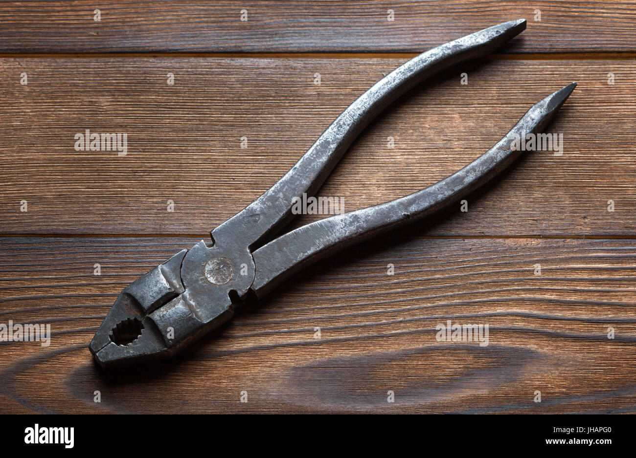 old rusty pliers on wooden background Stock Photo - Alamy