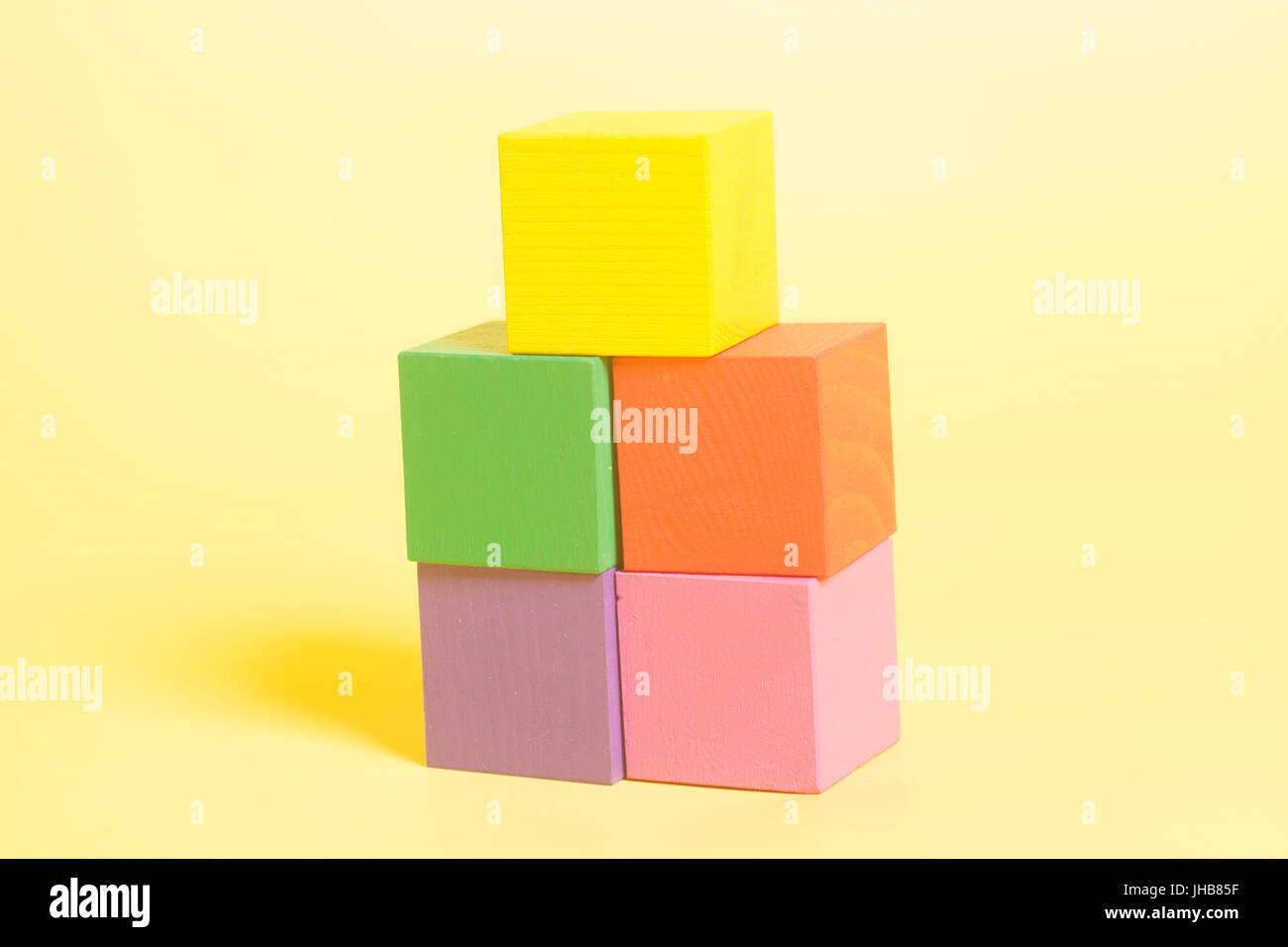 Multiple colored cubes on yellow background Stock Photo - Alamy