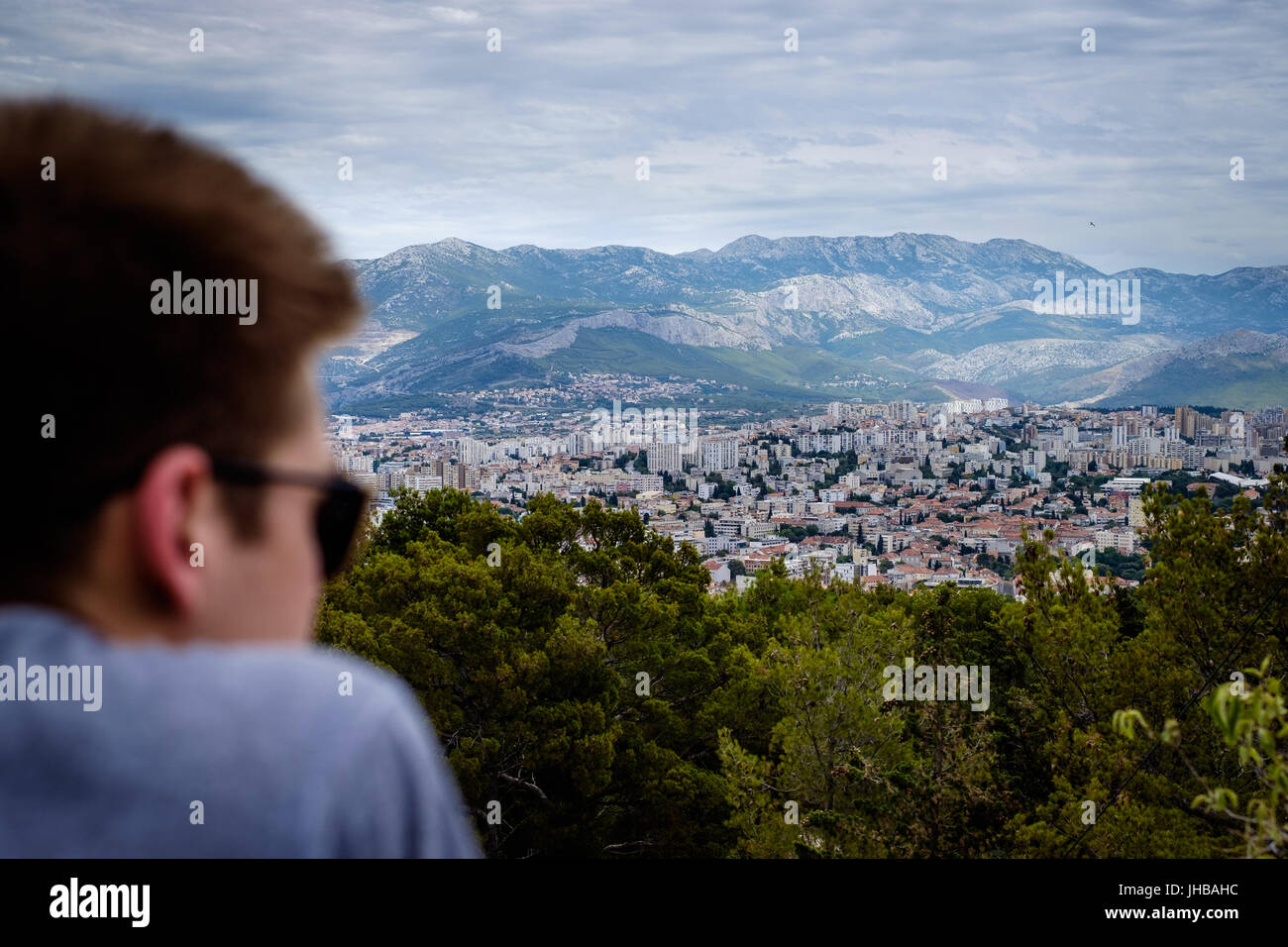 A young man enjoys the view of Split from above the city in Park Marjan ...