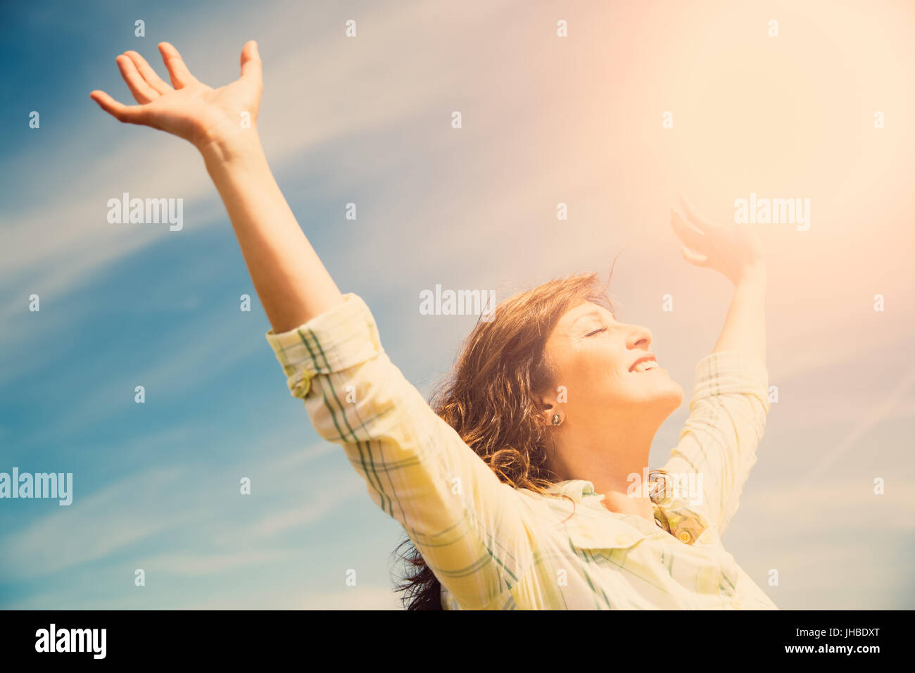 Attractive middle aged woman enjoying the sun and nature with ...