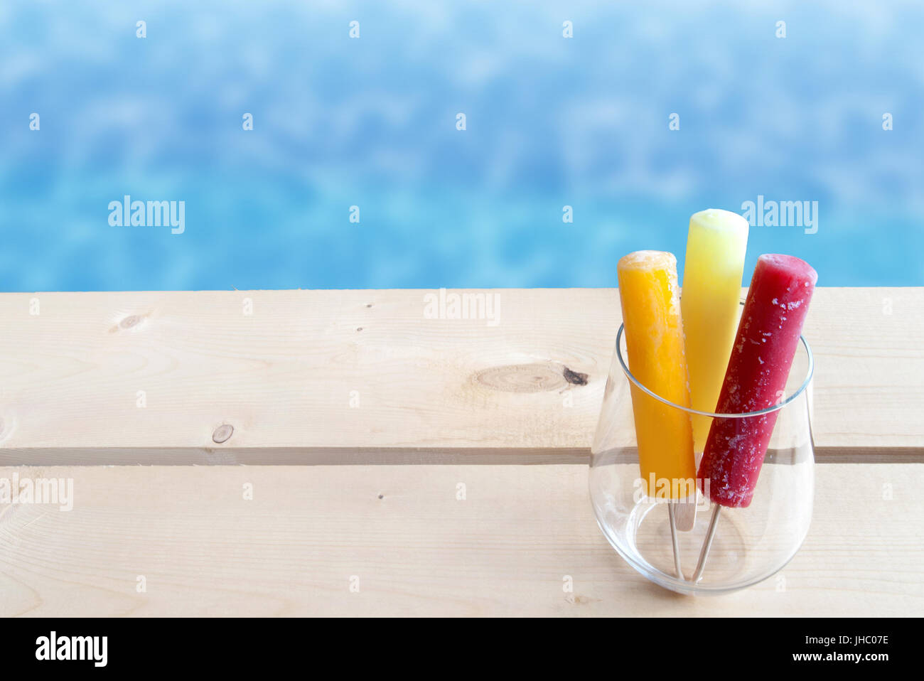 Frozen ice lollies in a glass by a swimming pool Stock Photo - Alamy