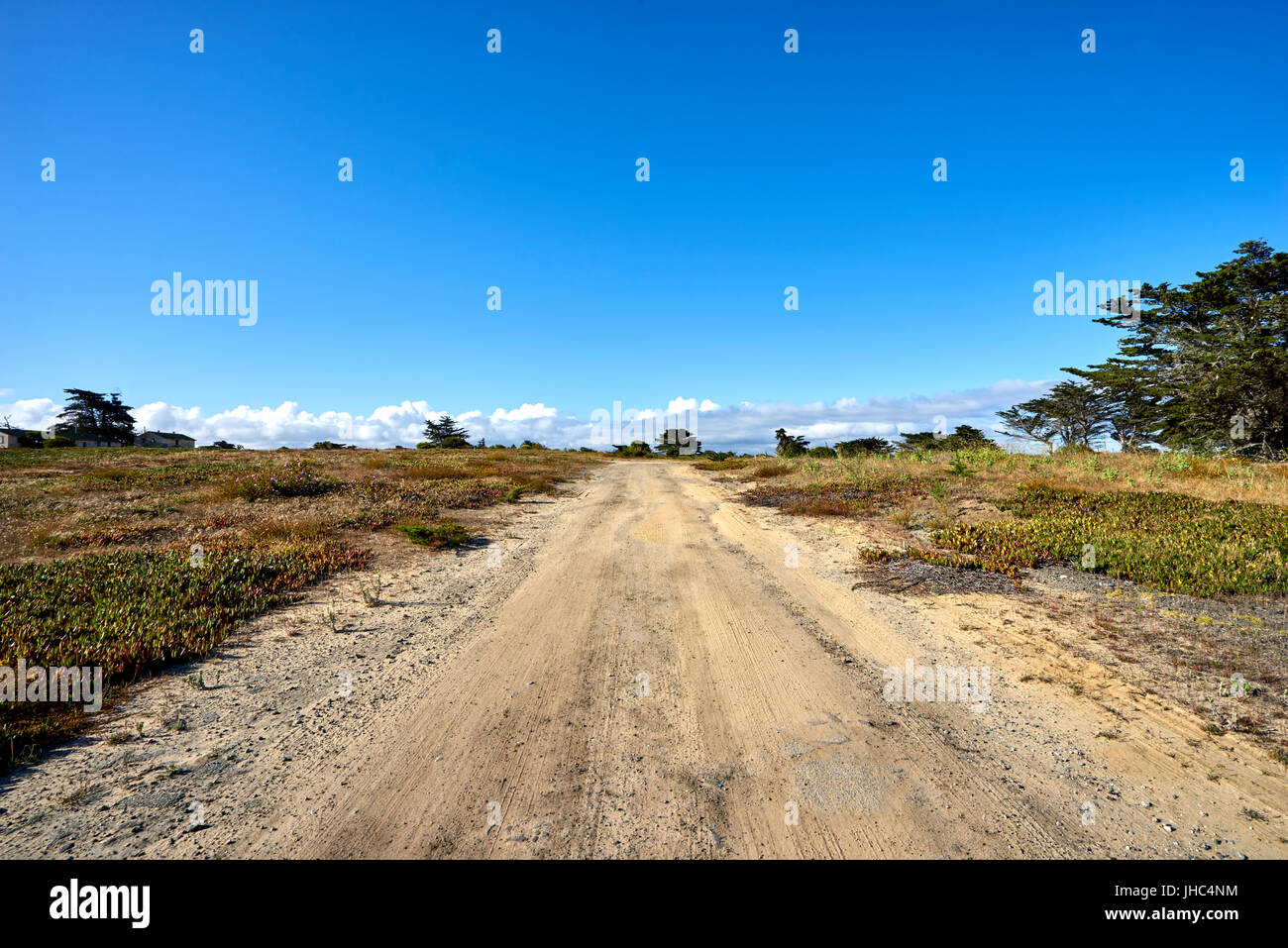 sand road towards deserted buildings on military installation Stock ...