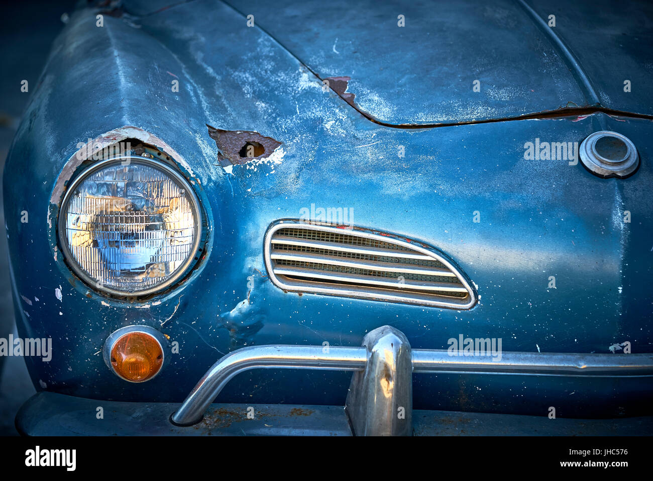 Vintage weathered unrestored blue German classic car with rust hole and ...