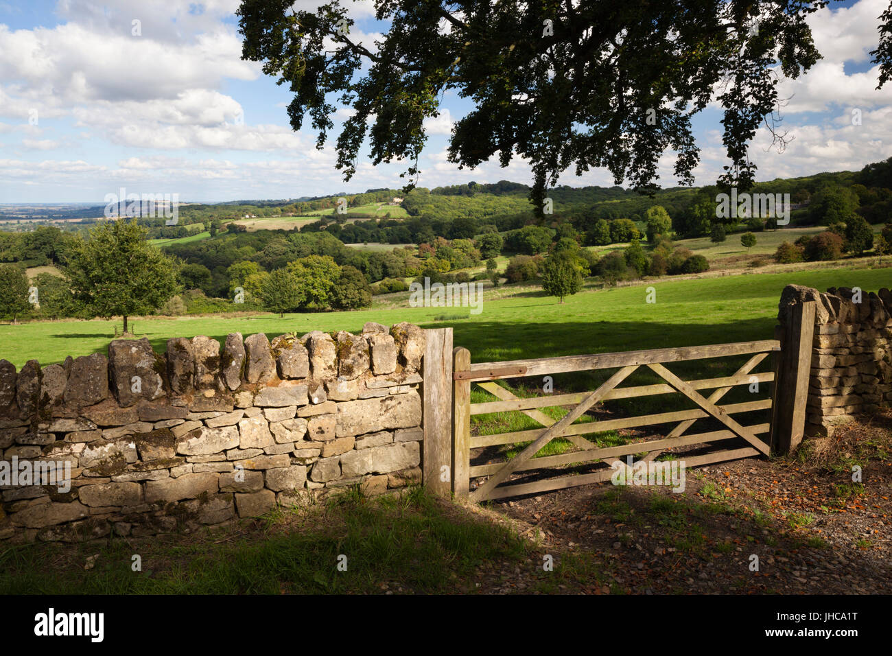 View over Cotswold landscape and drystone wall with wooden five bar ...