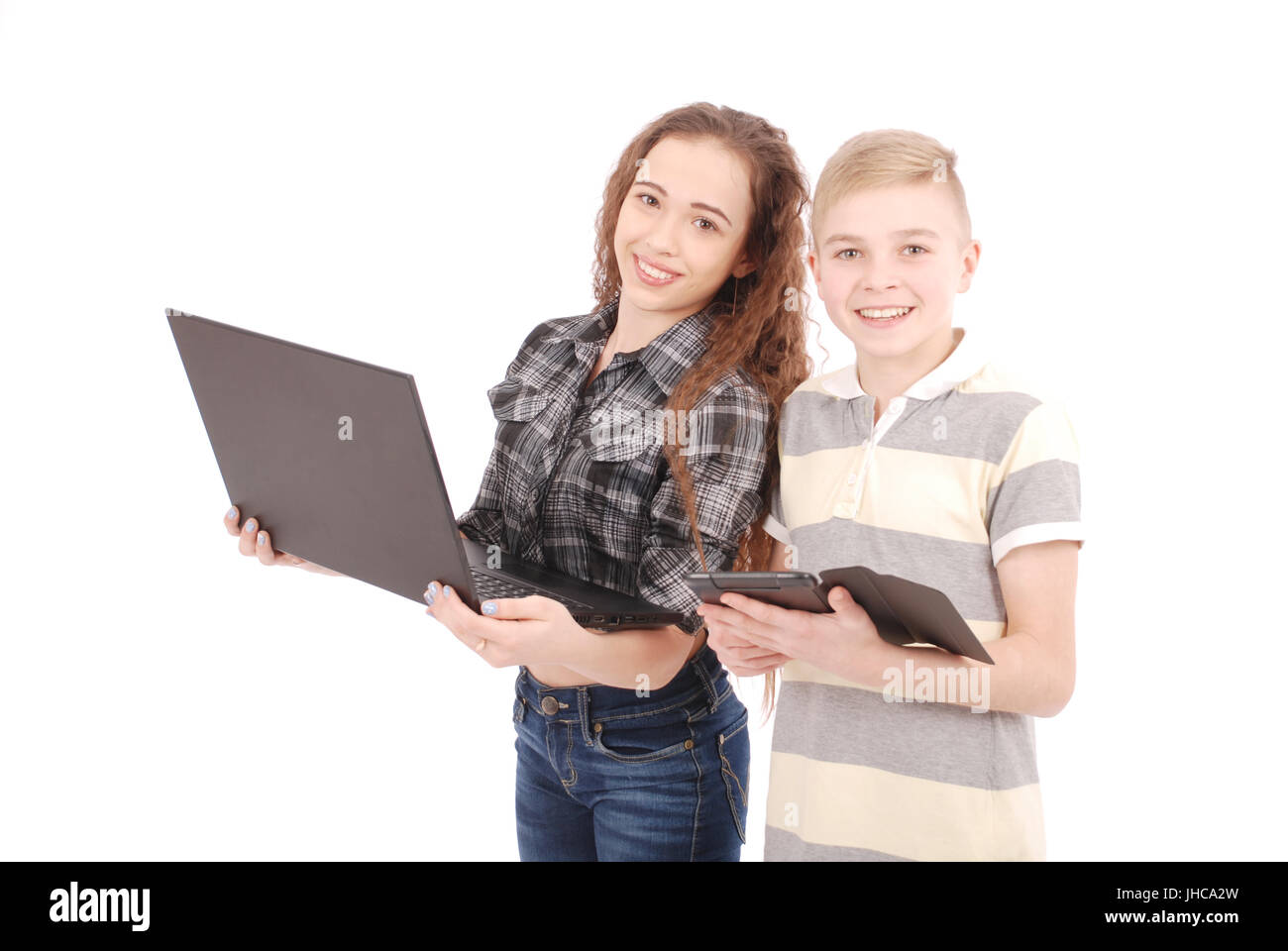 Two kids playing and surfing the web on digital tablet and laptop ...