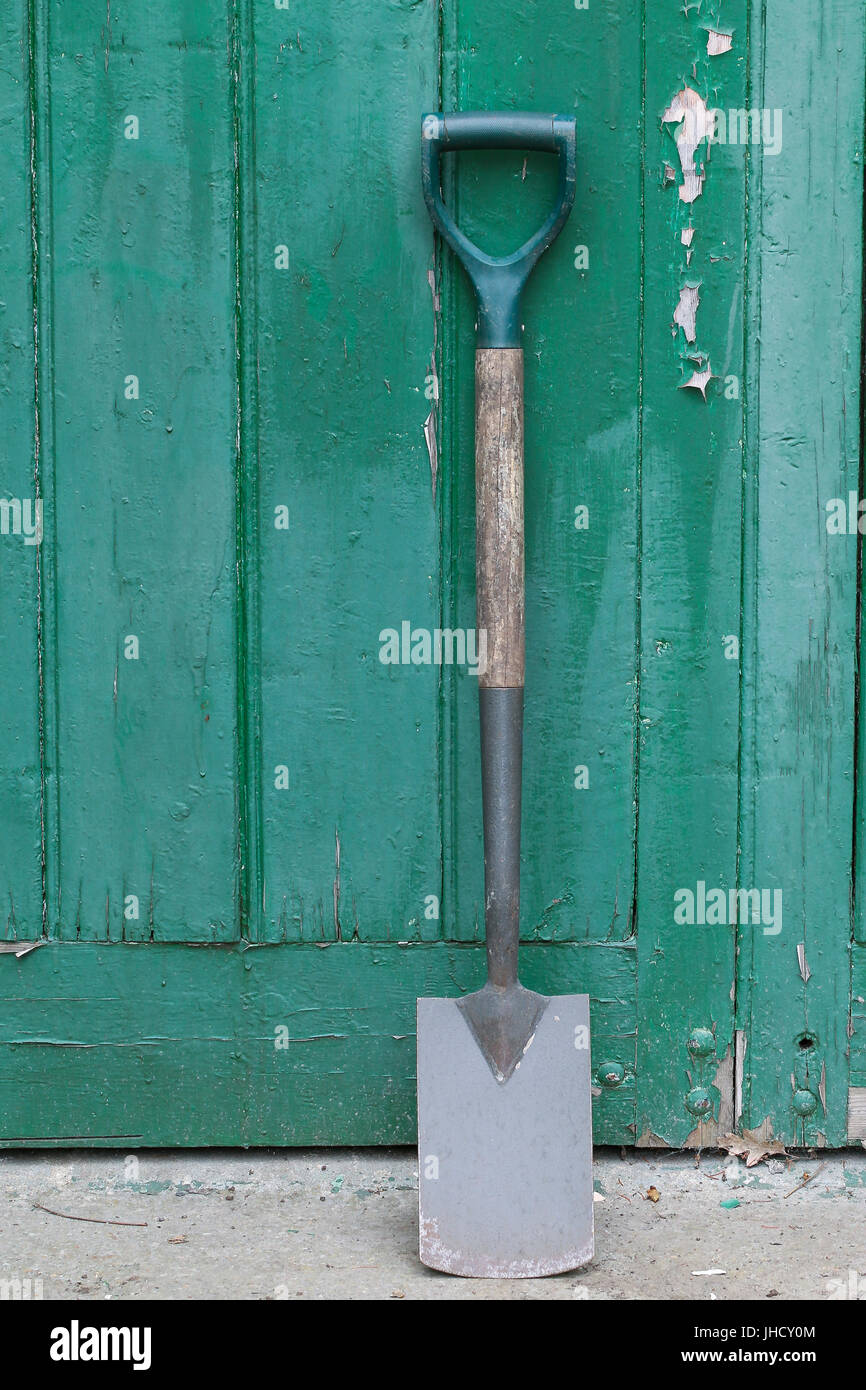 Old spade with green aged barn door Stock Photo - Alamy