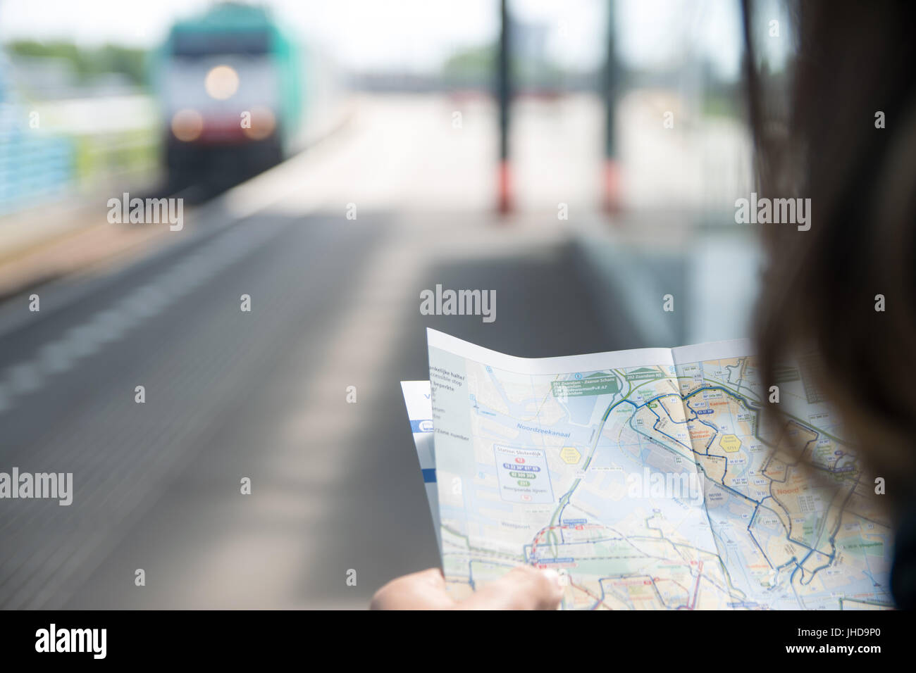 Woman with watching a map in a train station Stock Photo - Alamy