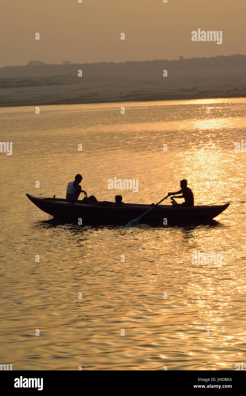Fishermen on wooden boats at Ganges river in Varanasi India. Due to ...