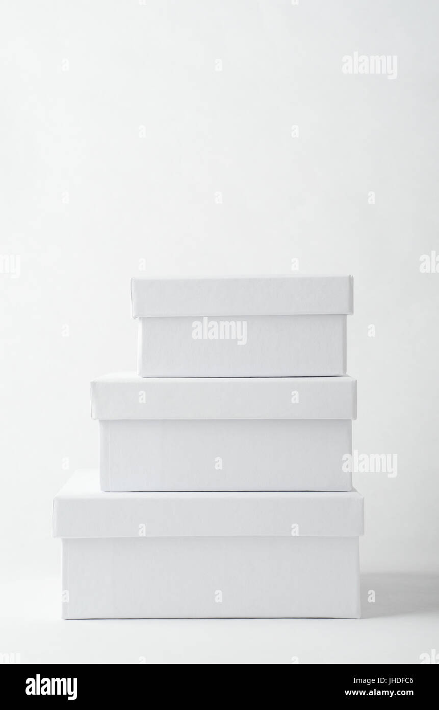 Photograph of a stack of three plain white gift or storage boxes ...