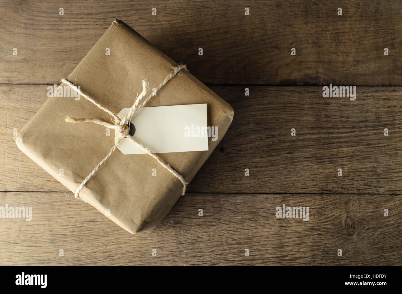 A square shaped parcel, wrapped in brown paper and tied with string ...