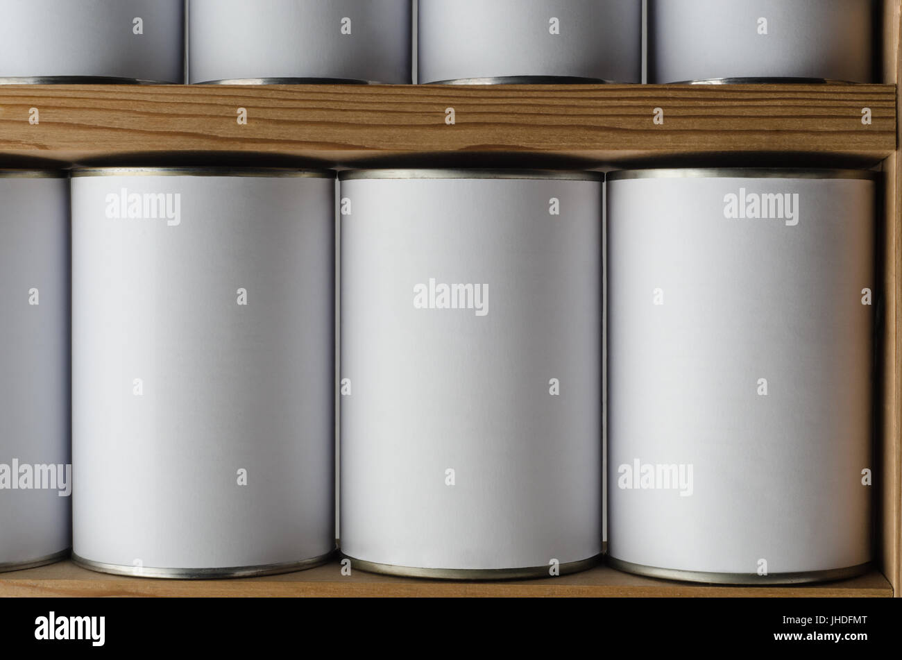 Rows of tin cans with unbranded, blank white labels, on wooden shelves ...