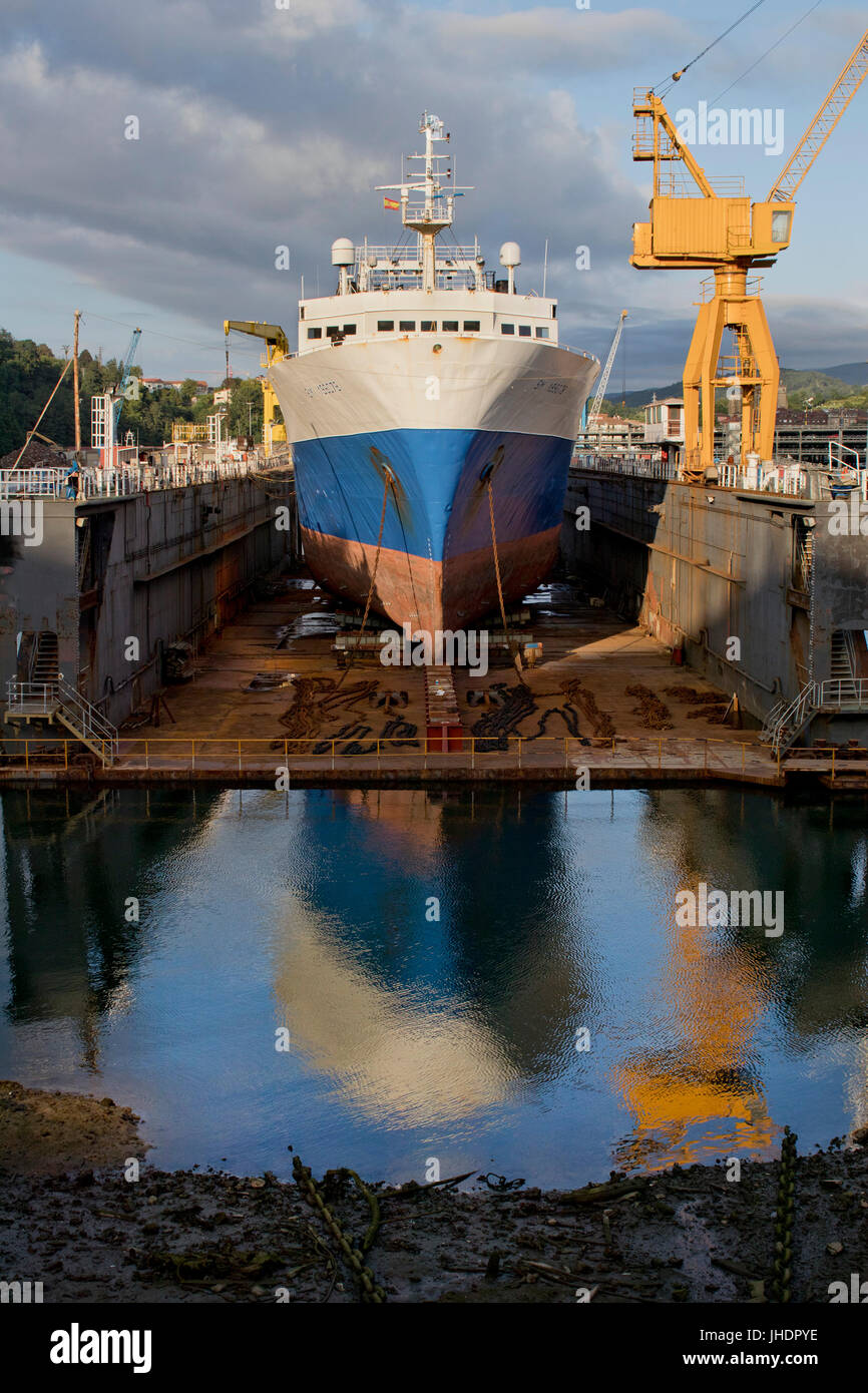 Ship and its own reflection on the water in a shipyard Stock Photo - Alamy