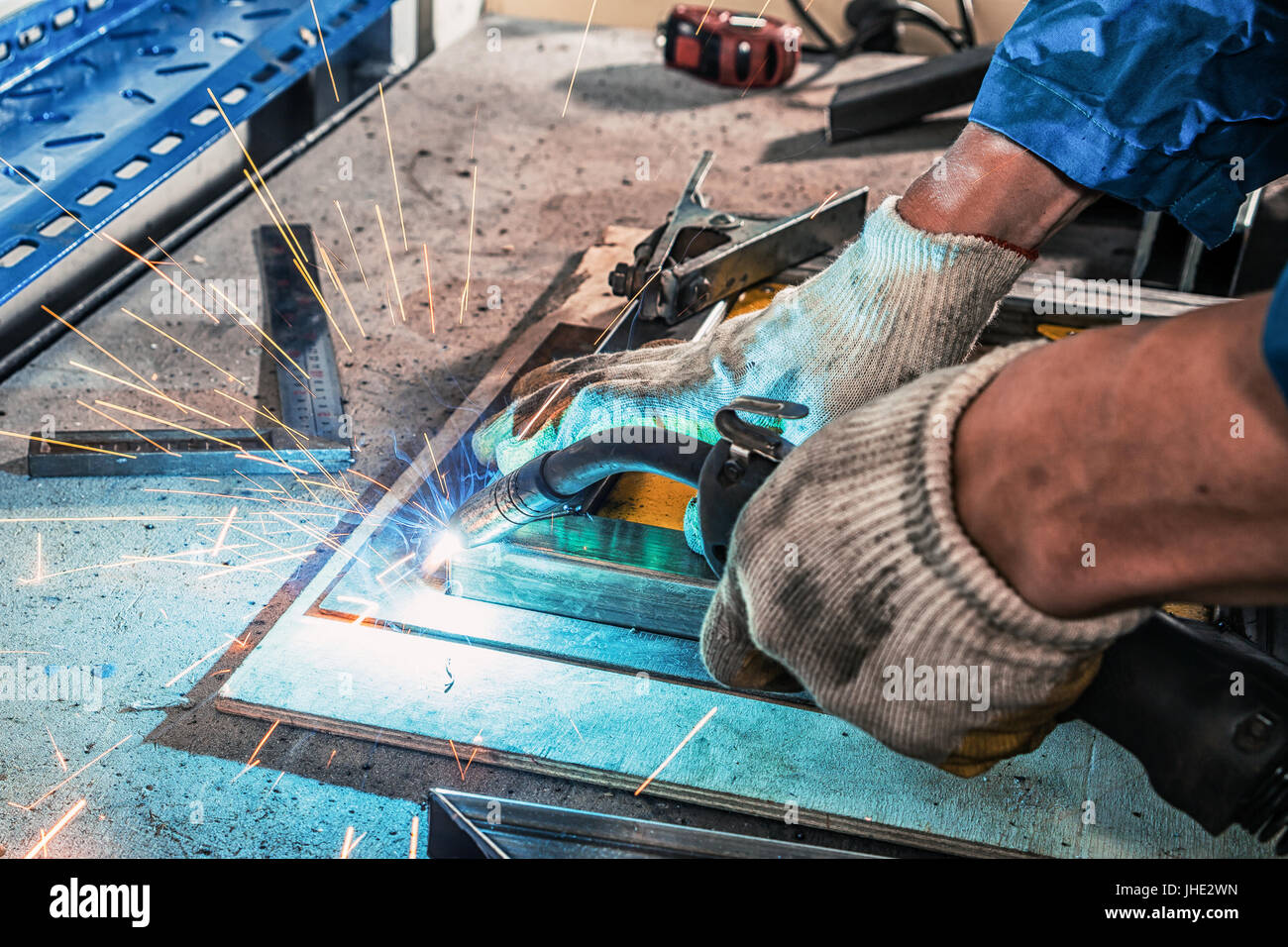Close-up A man welder in construction gloves weld a metal welding ...