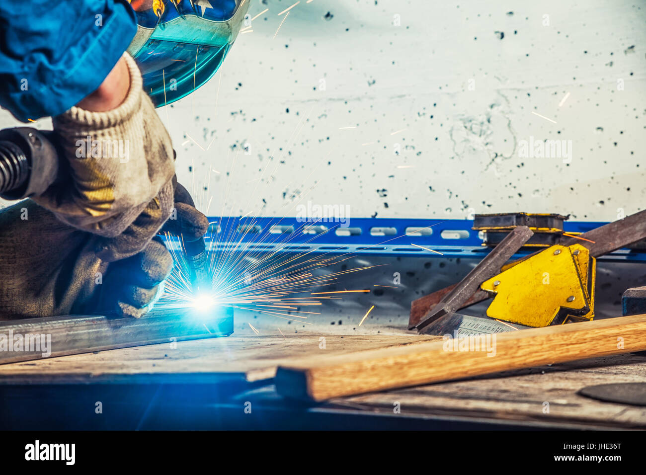 Close-up A man welder in construction gloves weld a metal welding ...