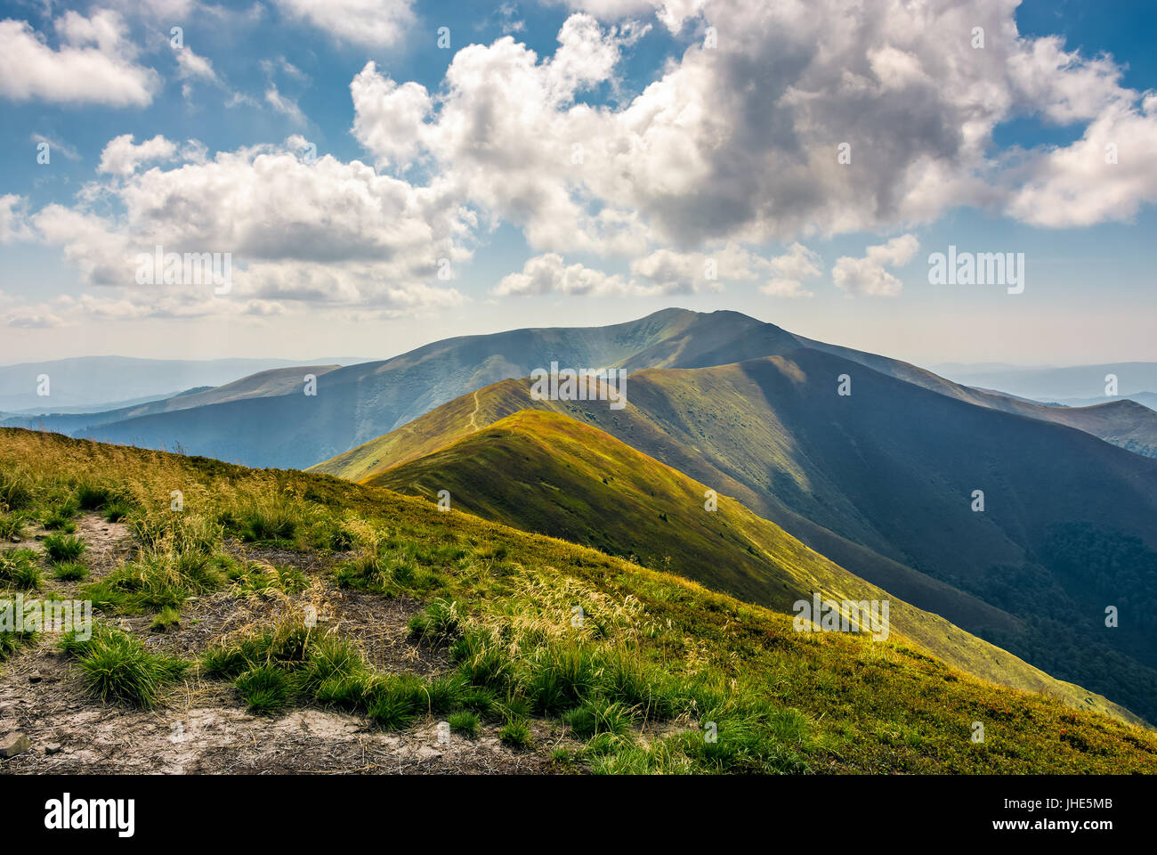 grassy hillside of mountain ridge. good weather with blue sky and few ...