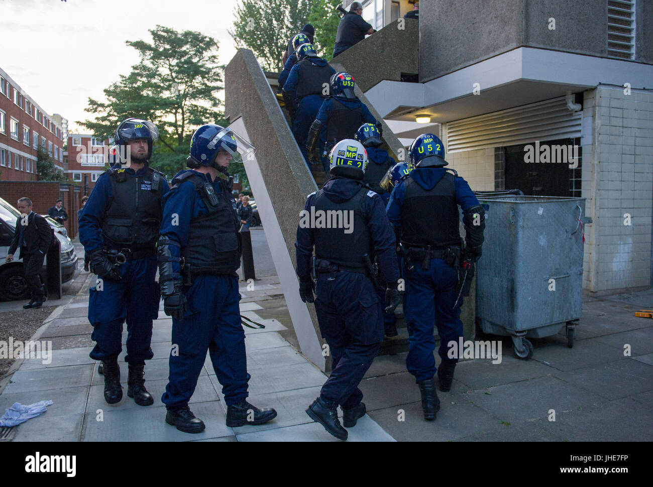 Police officers enter a block of flats in south London, where they will ...