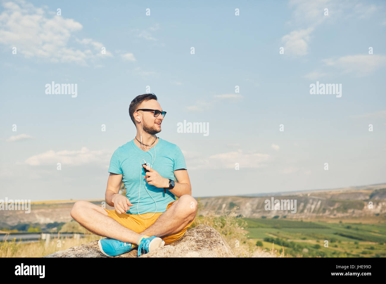 Young man wearing sunglasses smiling and enjoying sunny summer day ...