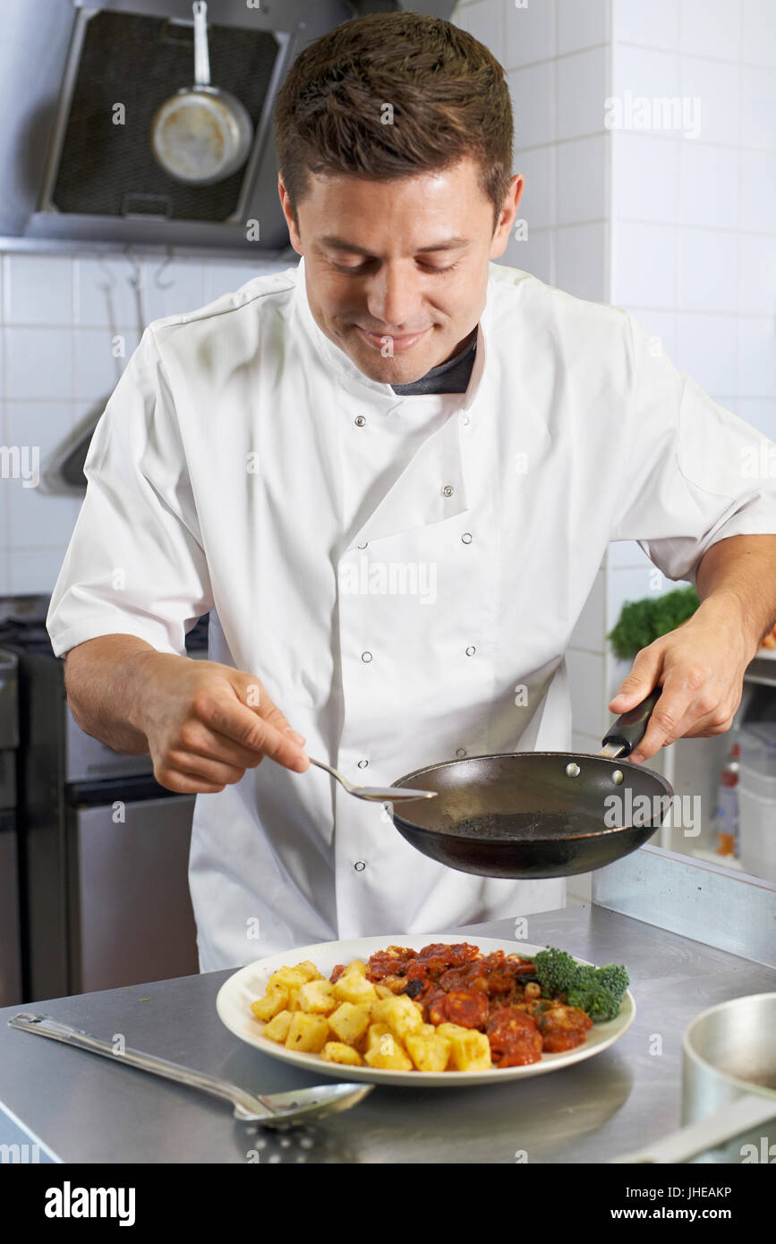 Chef Adding Sauce To Dish In Restaurant Kitchen Stock Photo - Alamy