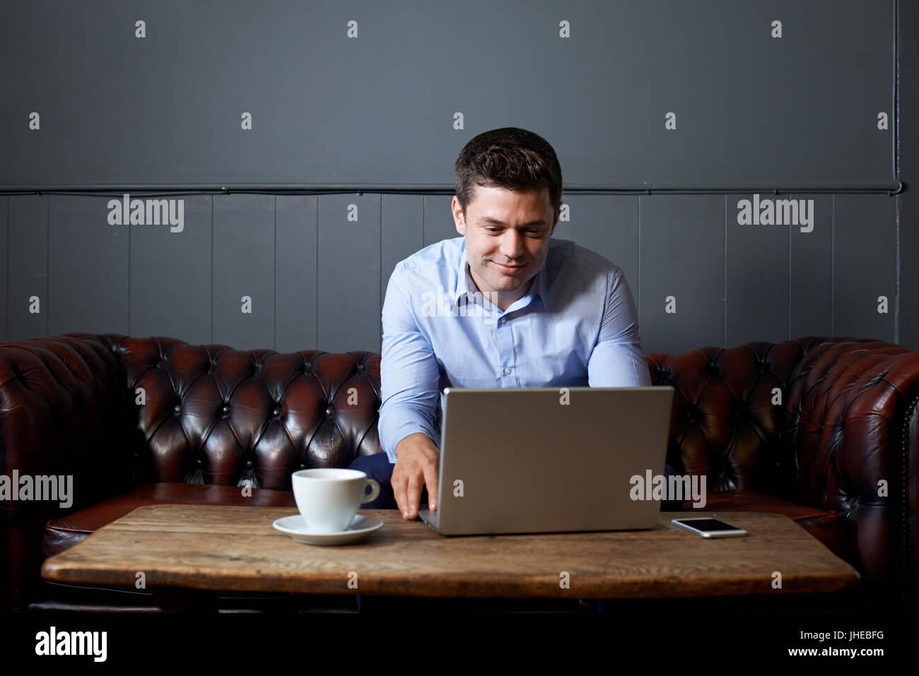 Man Working On Laptop In Internet Cafe Stock Photo - Alamy