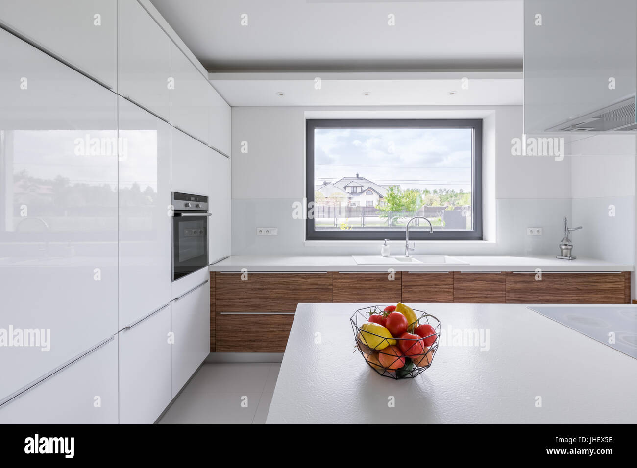 Modern design, white kitchen with island and big window Stock Photo - Alamy