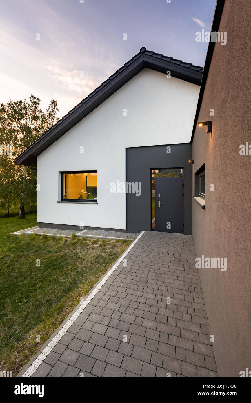 White, simple family house with cobblestone entry pathway Stock Photo ...