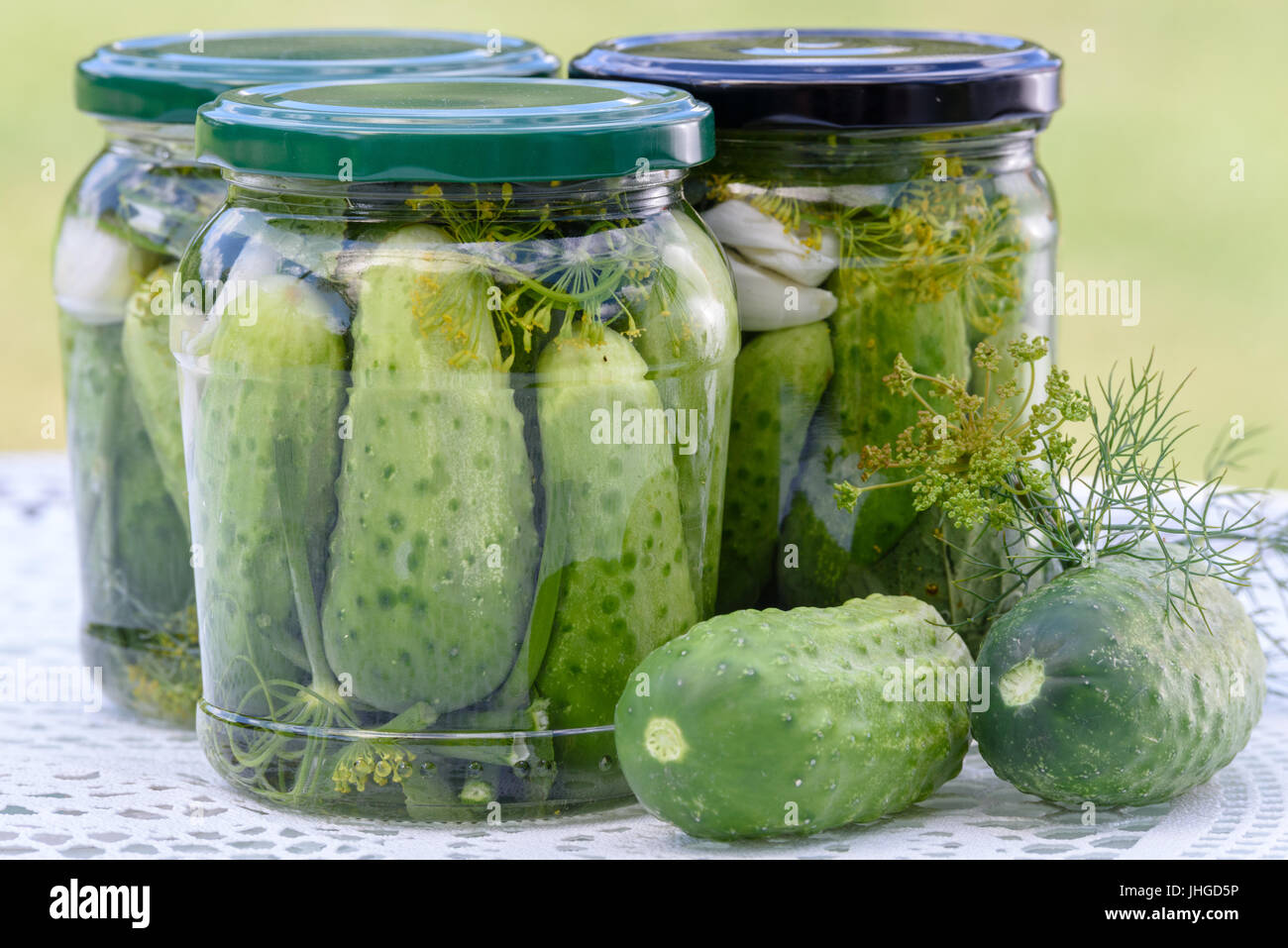 The concept of homemade preserves - jars of pickled cucumbers on a ...