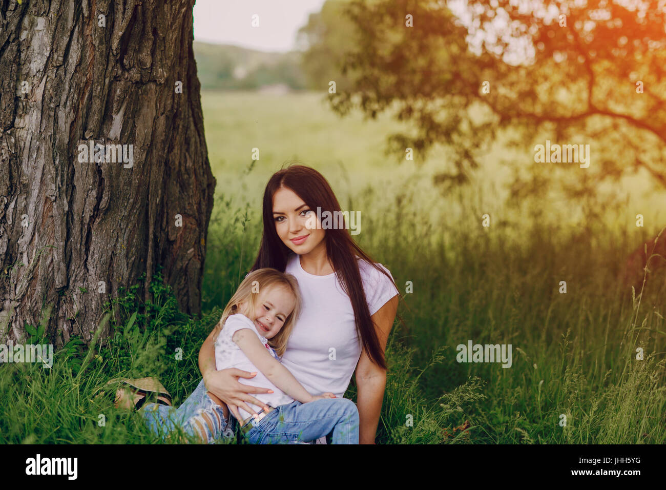 child near tree with mom Stock Photo - Alamy