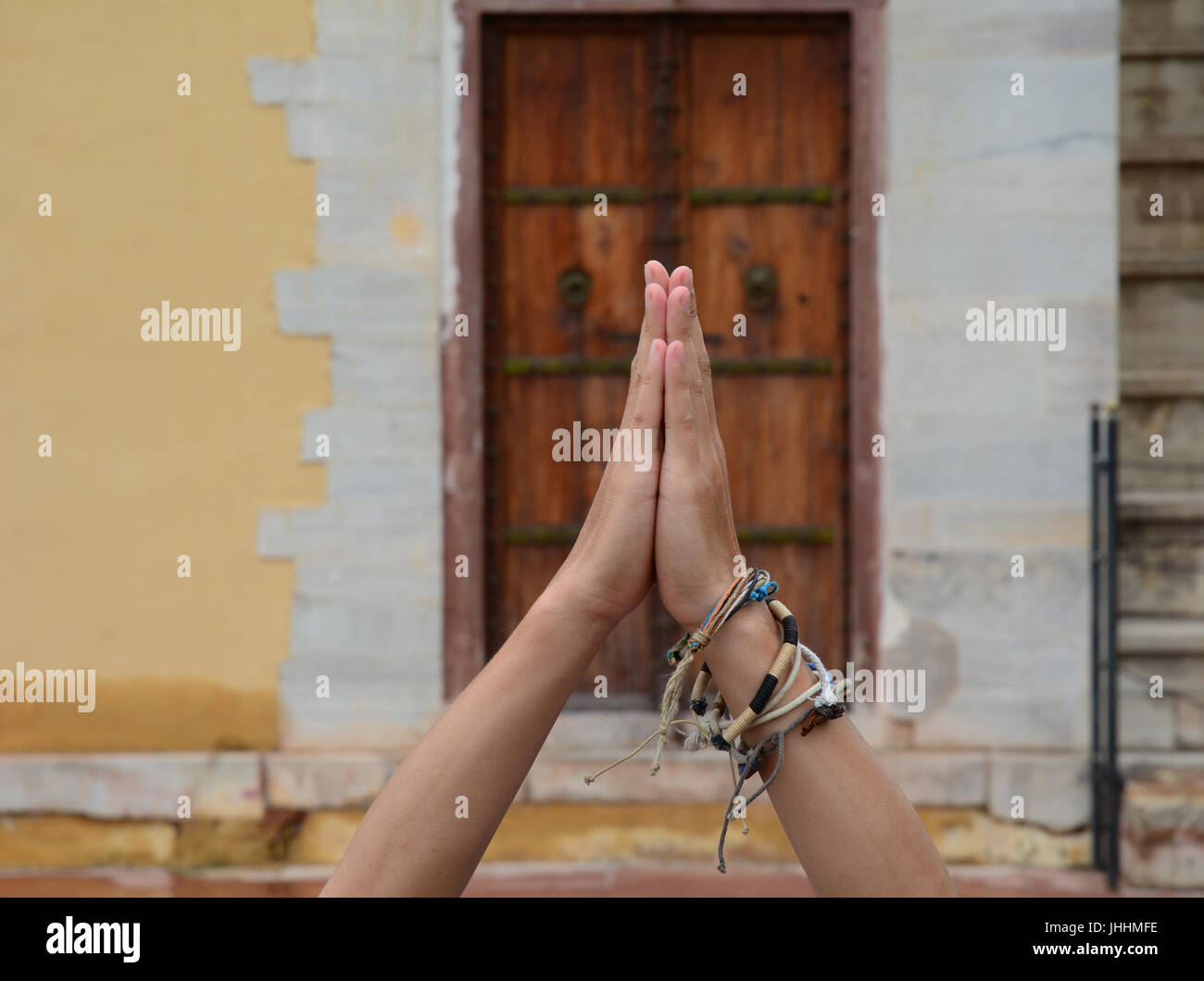 Praying hands with wooden door background at the old temple in India ...