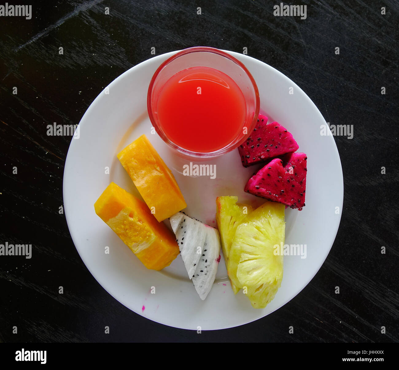 Plate with tropical fruits (dragon fruit, papaya and pineapple ...