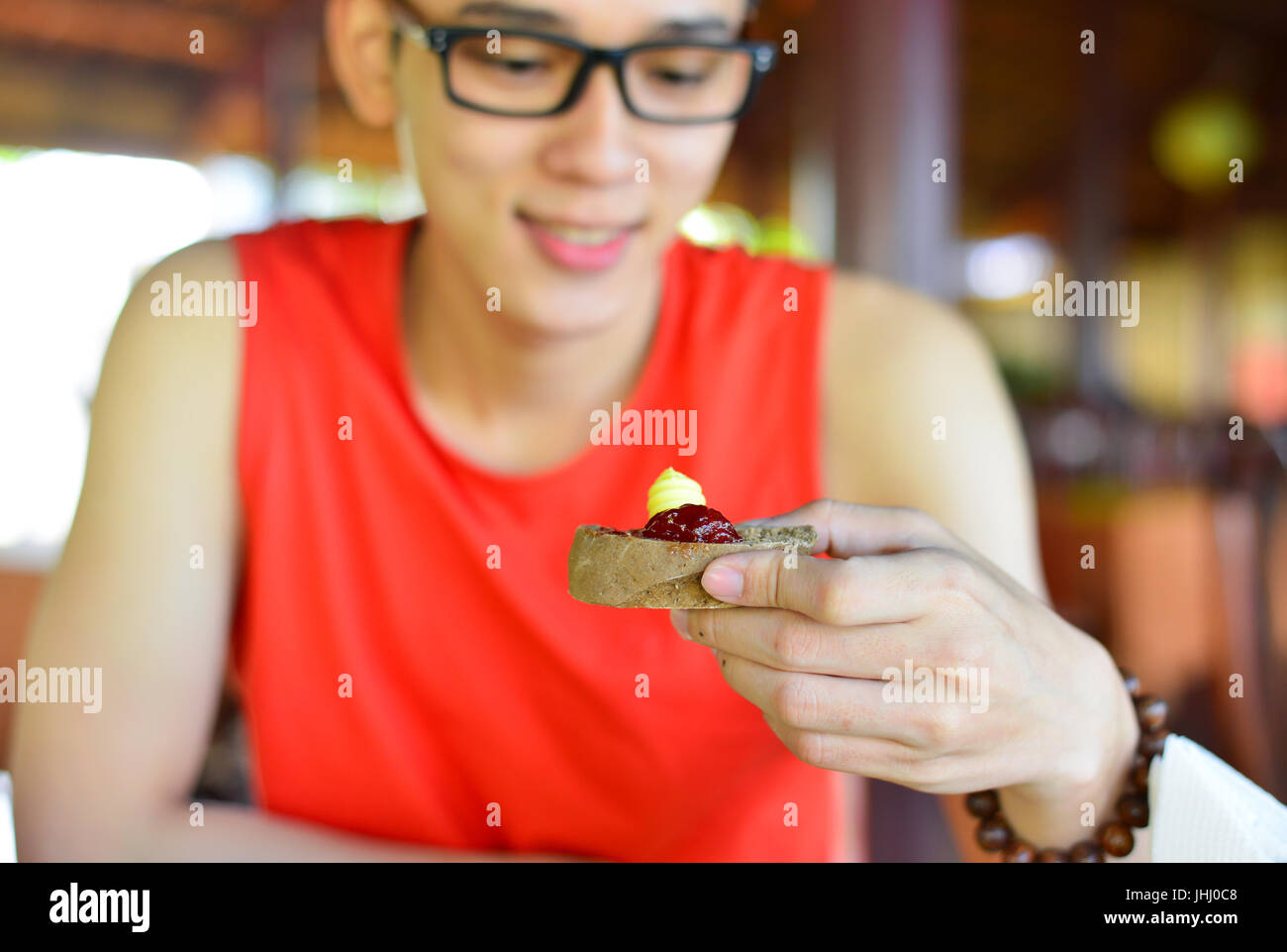 Asian man has breakfast at local restaurant in Vietnam. Focus on bread ...