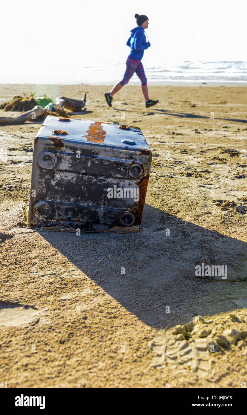 Discarded metal container wahed up on beach after high tide. Wales. UK ...