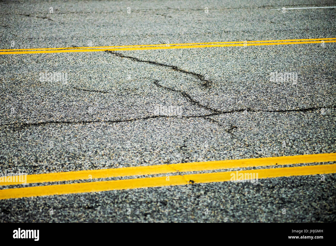A section of cracked pavement with traffic lines Stock Photo - Alamy