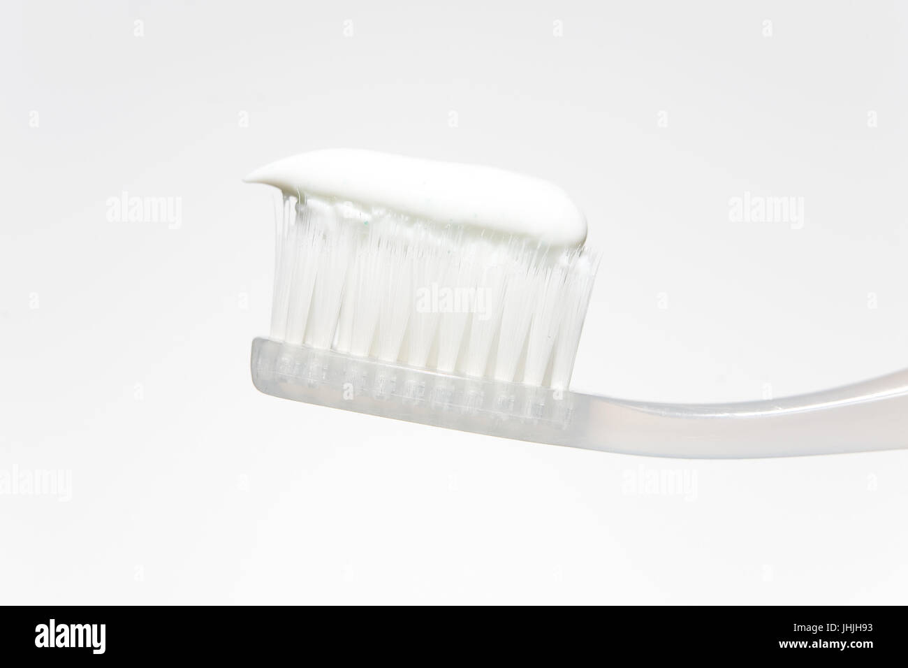 Hygiene products: toothpaste on the toothbrush in a light tone Stock ...