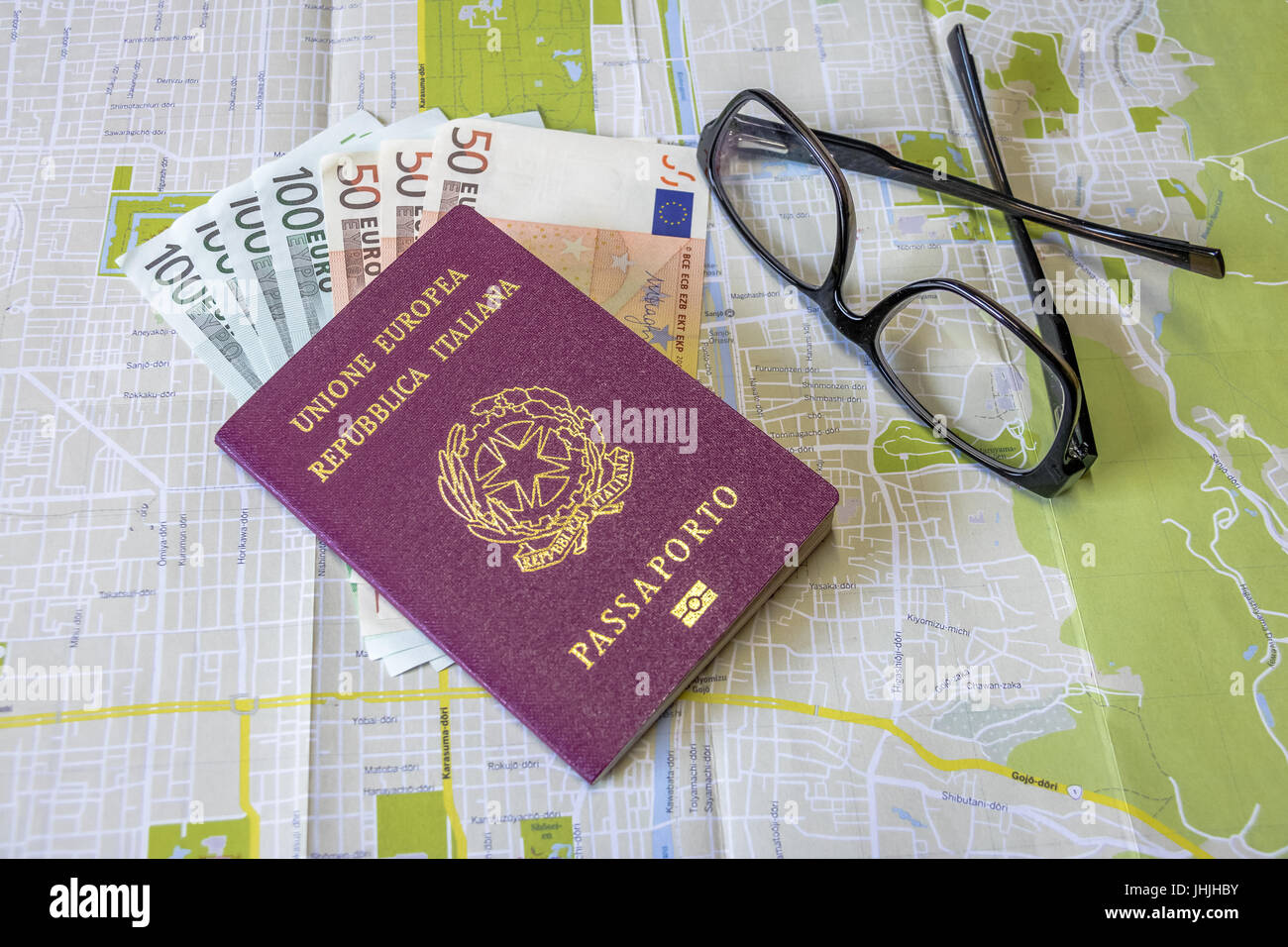 Planning a trip - Italian passport on city map with euro bills money ...