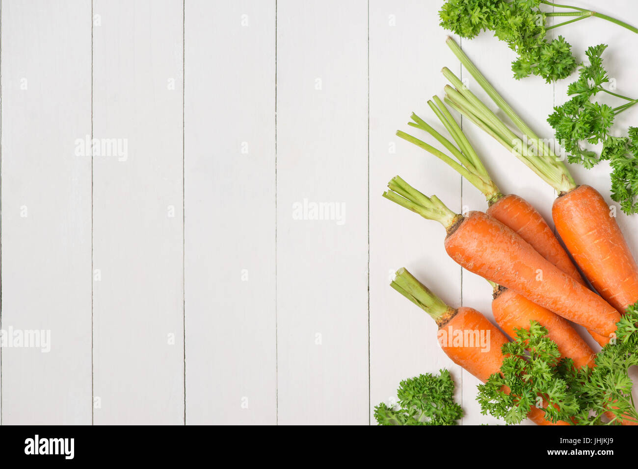 Fresh raw carrots with vegetables on wooden table Stock Photo - Alamy