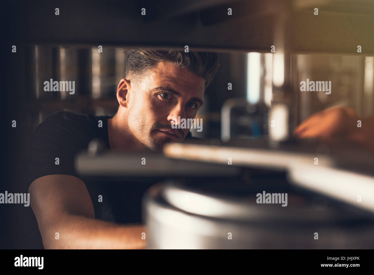 Brewer working on beer production line at brewery. Man working at ...