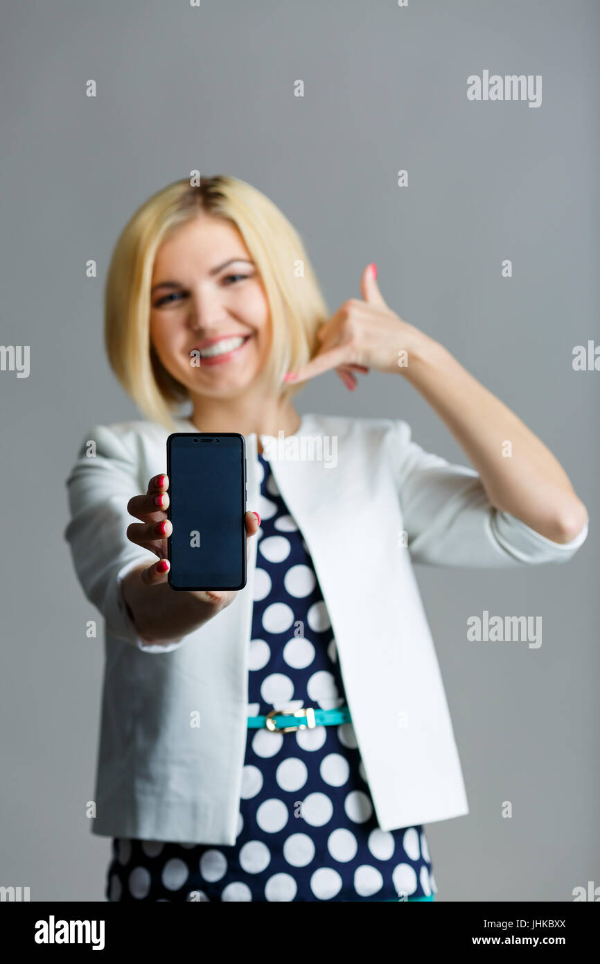 Woman with phone showing shaka Stock Photo - Alamy