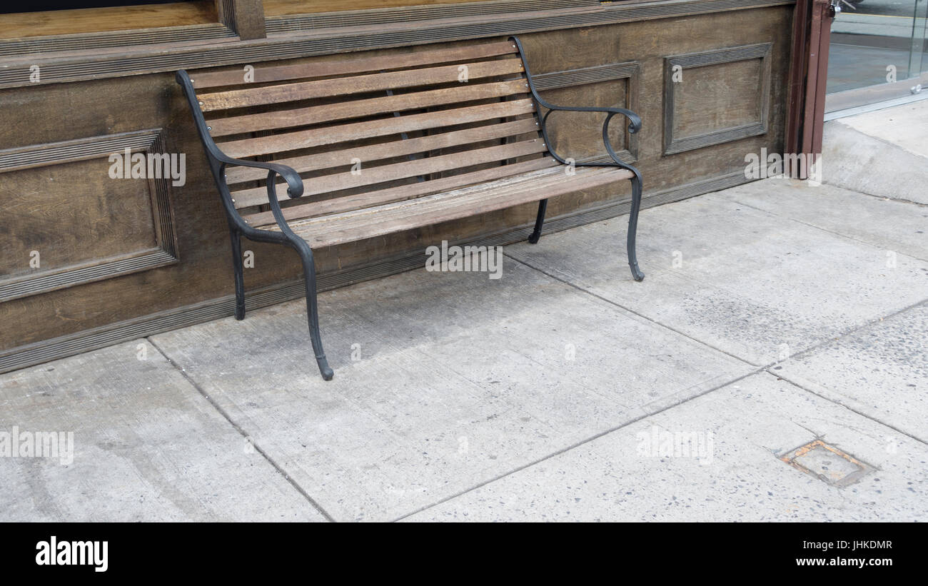 wood and medial classic bench outside storefront walkway sidewalk Stock ...
