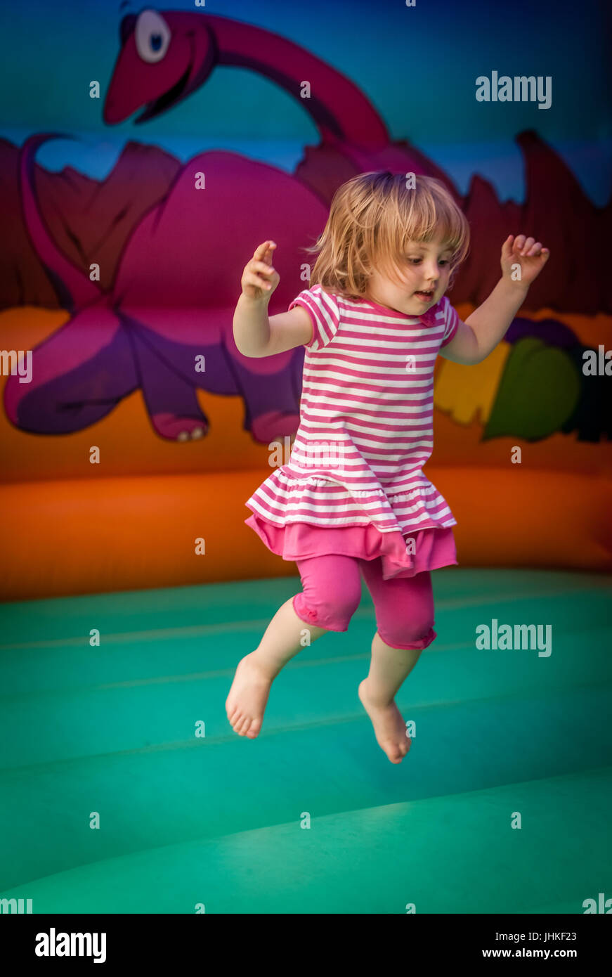 Cute little girl jumping inside the inflatable bouncy castle Stock ...
