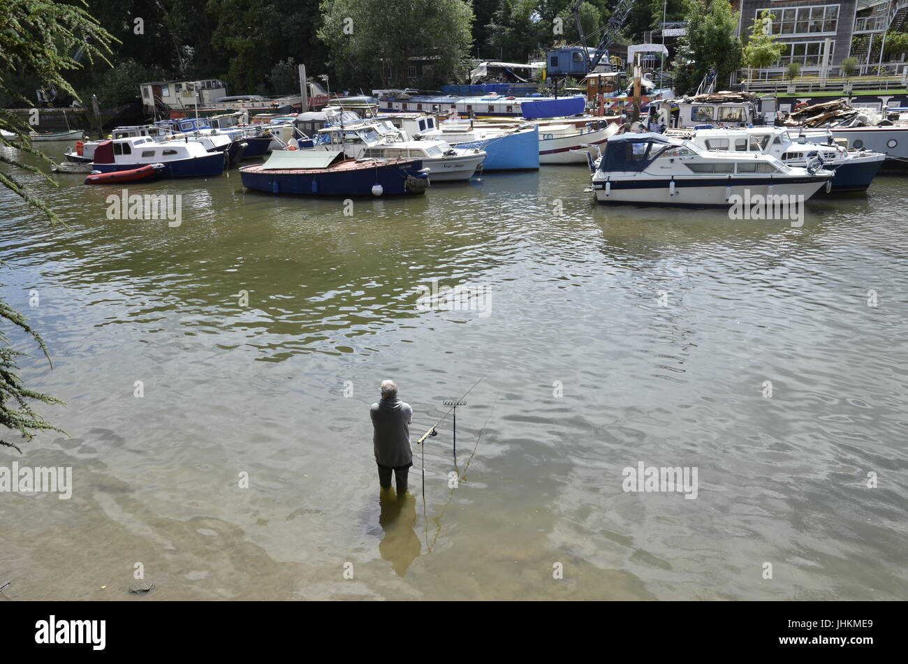 A man fishing in the River Thames between Twickenham and Eel Pie Island ...