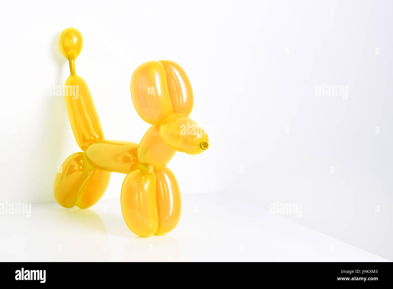 Simple yellow twisted balloon animal dog on white. Toy of balloons ...