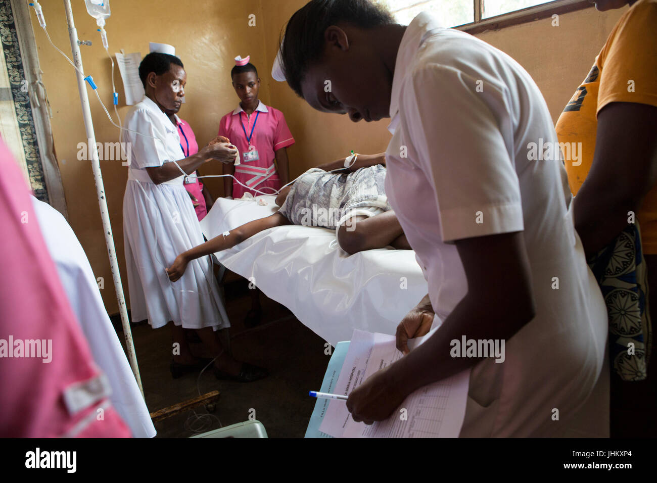 A nurse, making notes of the patients scores and observations during a ...